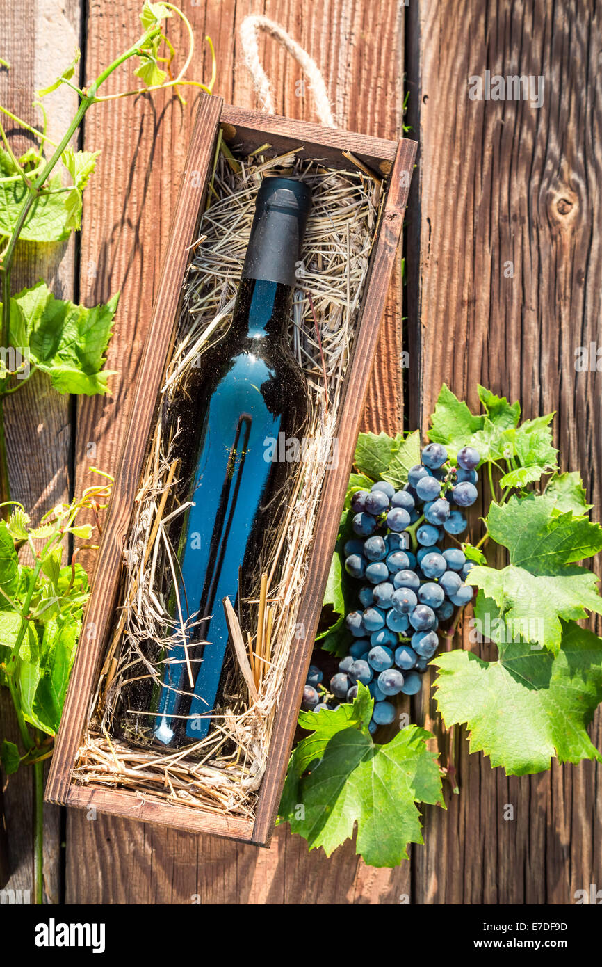 Red wine in a wooden box with hay Stock Photo - Alamy