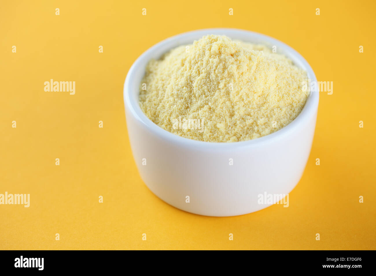 Corn flour in a bowl on yellow background Stock Photo - Alamy
