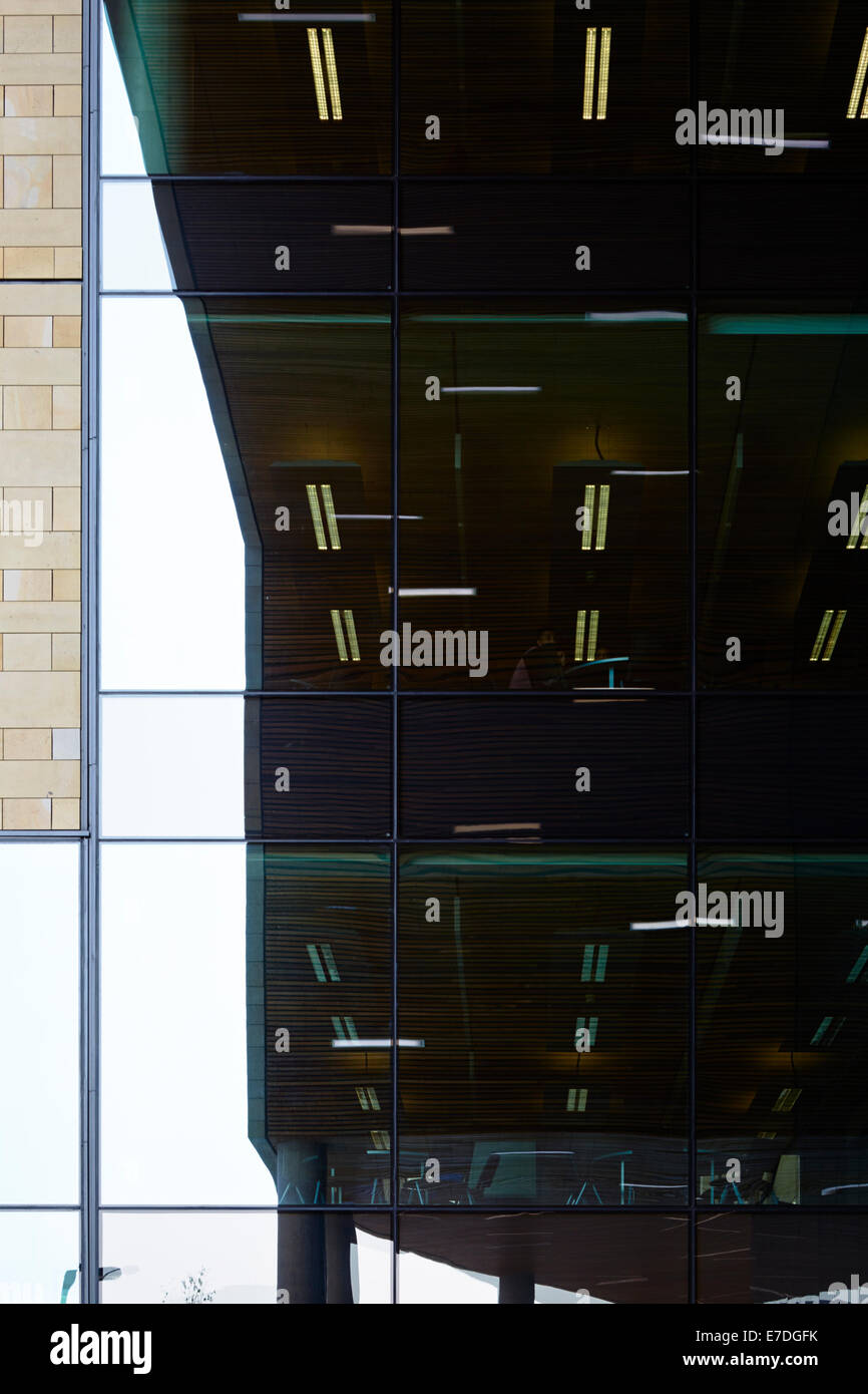 High contrast reflections of building with interior lights in modern ...