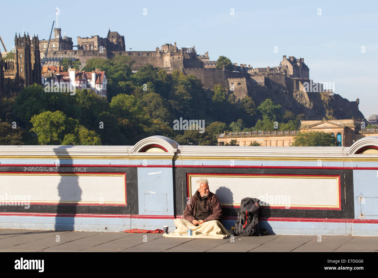Homeless man begging on the North Bridge, with Edinburgh Castle in the ...