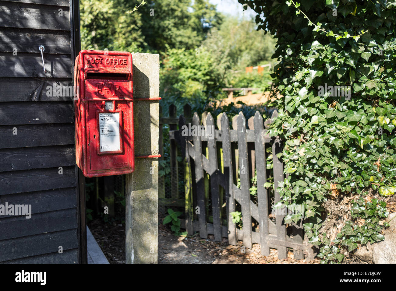 Old fashioned red post box by a picket gate in rural Suffolk Stock ...