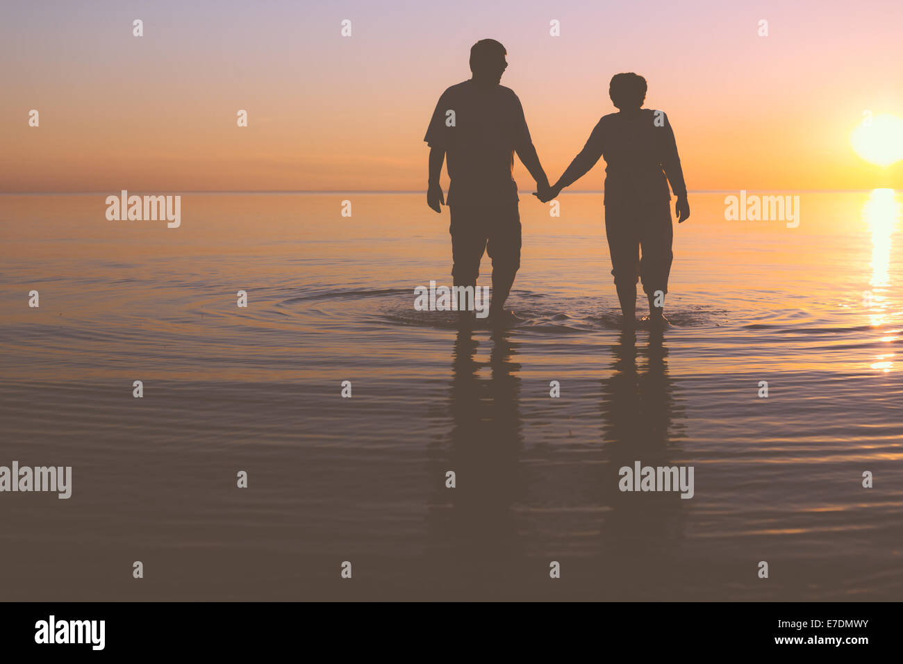 Senior couple walking at sunset Stock Photo - Alamy