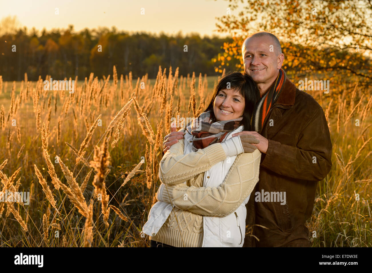 Romantic couple hugging enjoy autumn sunset countryside looking away ...