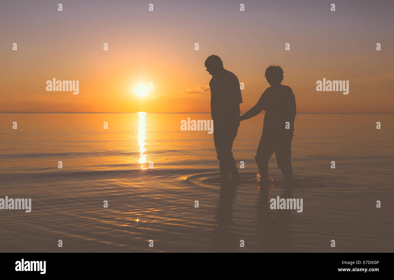 Senior couple walking at sunset Stock Photo - Alamy