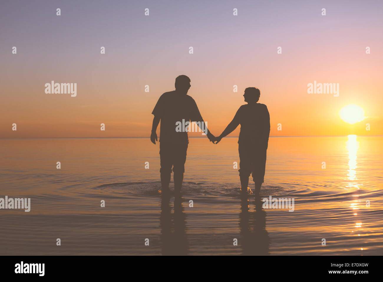 Senior couple walking at sunset Stock Photo - Alamy