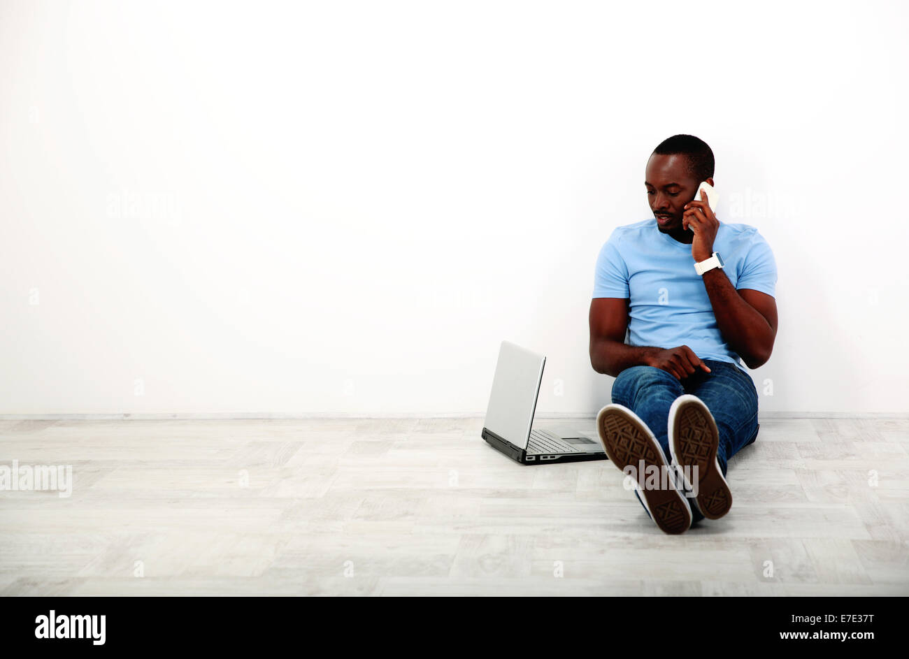 African man phone sitting hi-res stock photography and images - Alamy