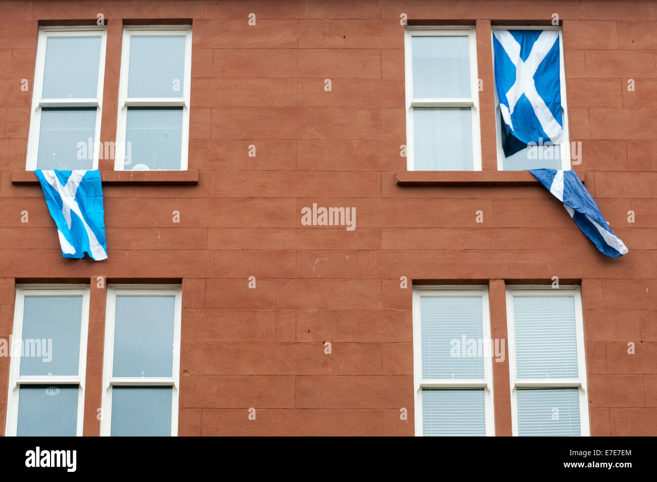 St. Andrews flags hung outside a typical Glasgow tenement building ...