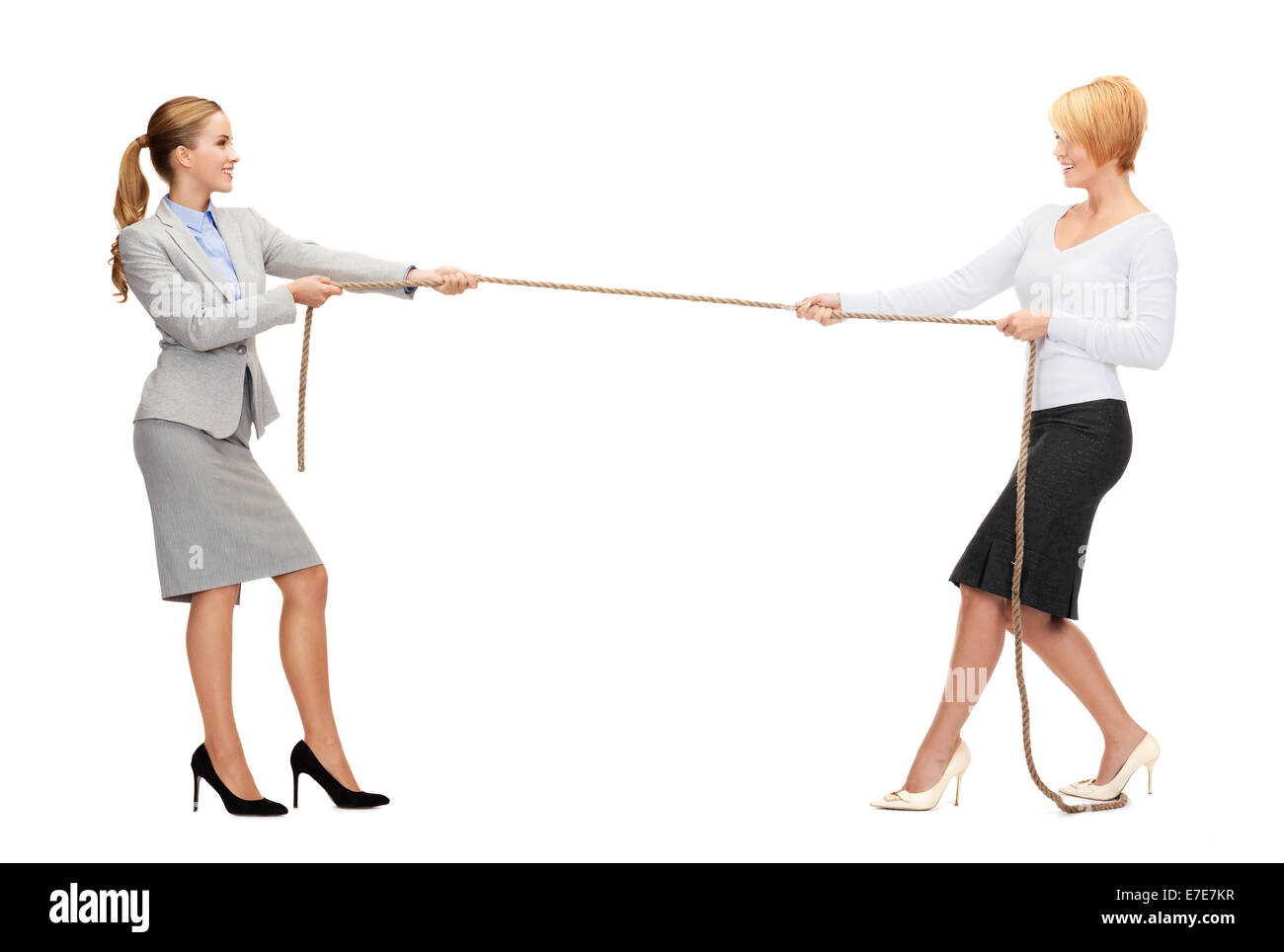 two smiling businesswomen pulling rope Stock Photo - Alamy
