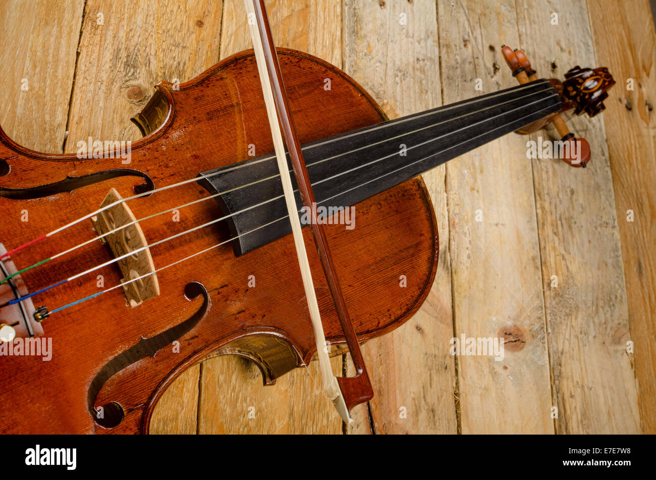 Old viola and arch on a wooden background Stock Photo - Alamy