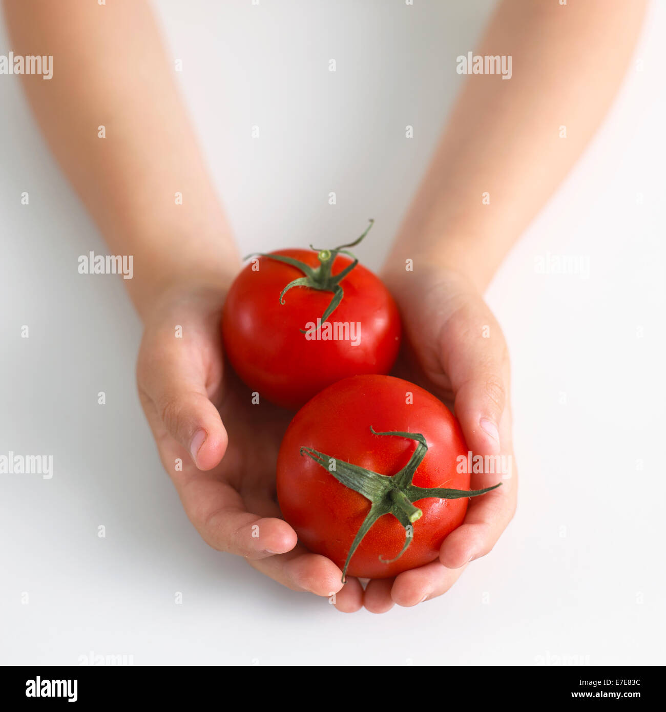Holding two tomatoes Stock Photo - Alamy