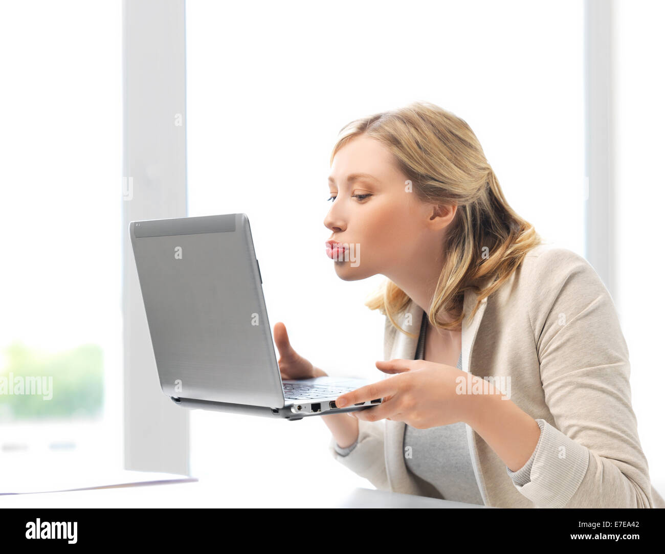 woman sending kisses with laptop computer Stock Photo - Alamy