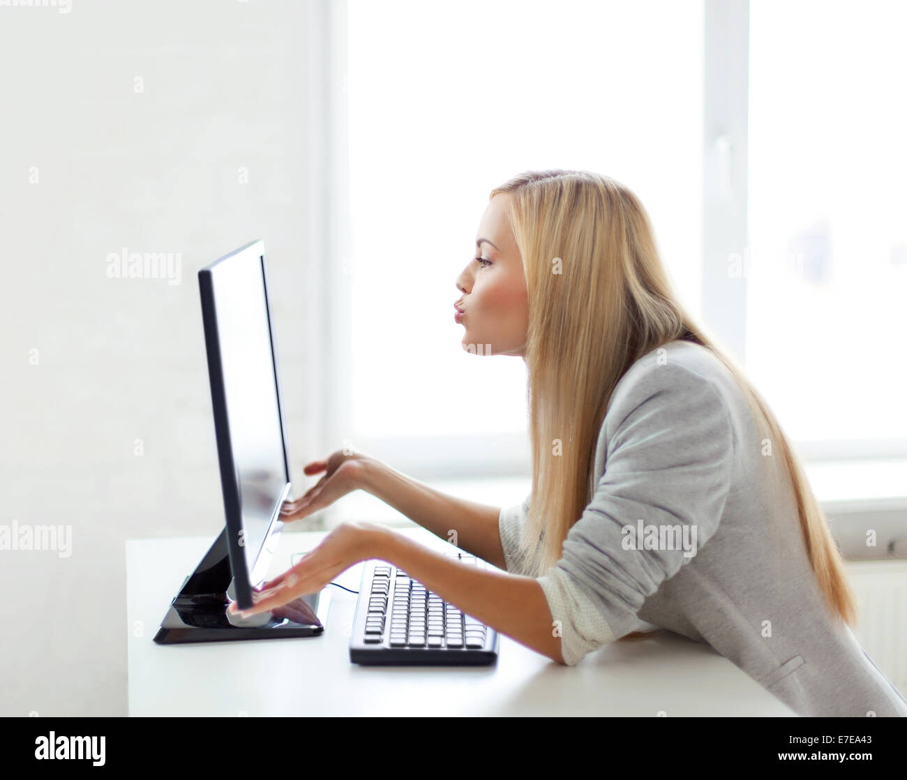 woman sending kisses with computer monitor Stock Photo - Alamy