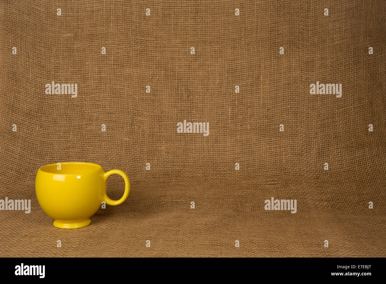 Coffee Mug Background. Yellow mug on burlap. Copy space Stock Photo - Alamy