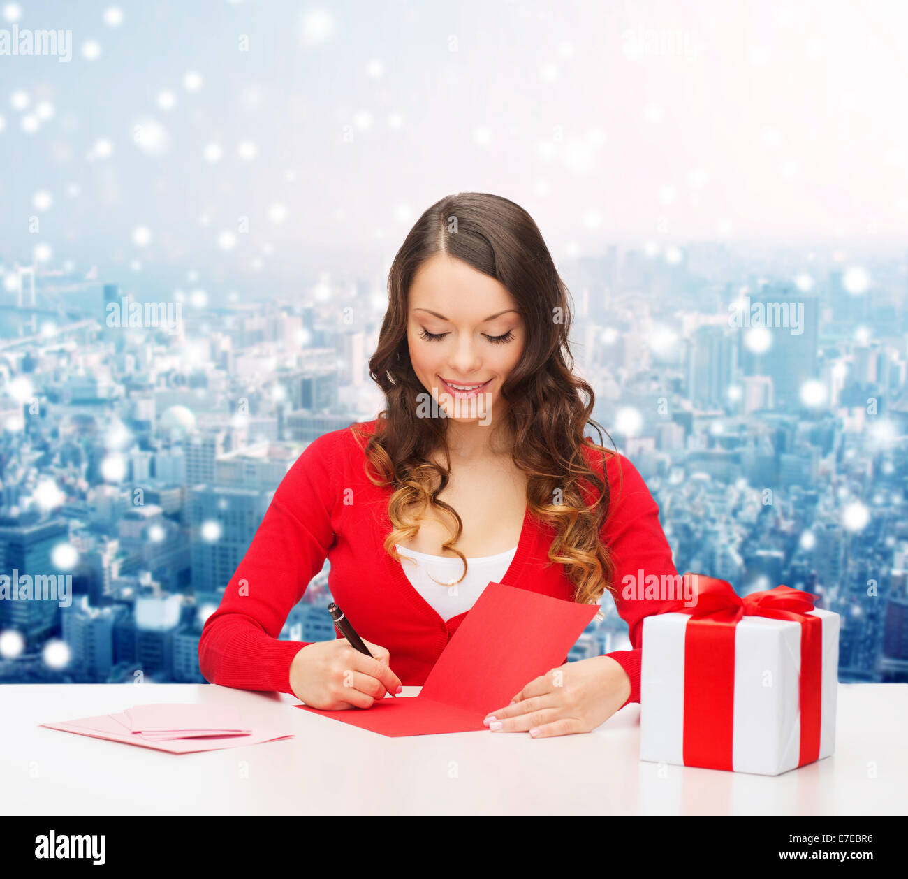 smiling woman with gift box writing letter Stock Photo - Alamy