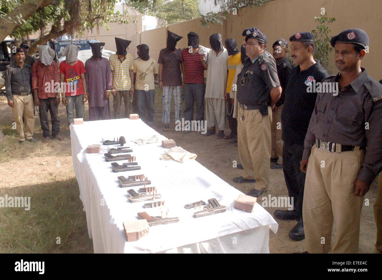 Police officer exposing criminals and seized weapon recovered from them ...