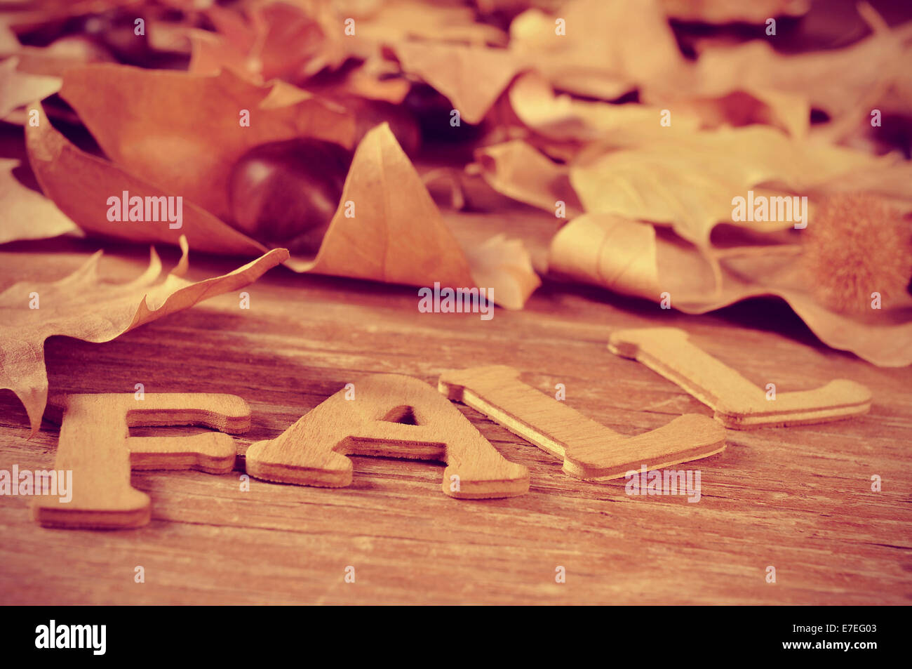 wooden letters forming the word fall and some autumn leaves on a ...