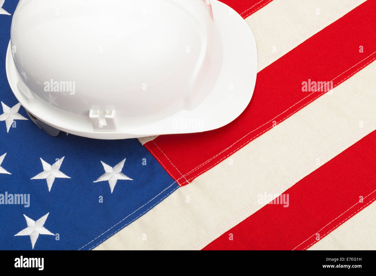 White color construction helmet laying over US flag Stock Photo - Alamy