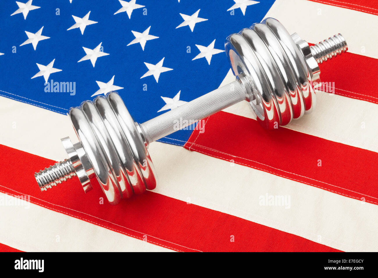 Metal dumbbells over USA flag as symbol of healthy nation - studio shot ...