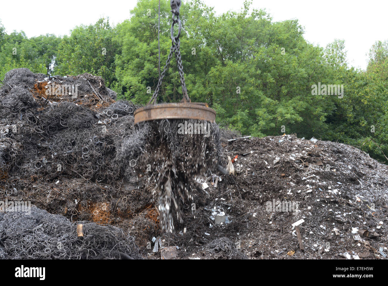magnetic grab on crane lifting metal at scrapyard uk Stock Photo - Alamy