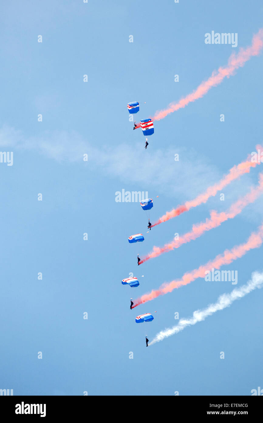 RAF falcons parachute team in flight against a blue sky trailing ...