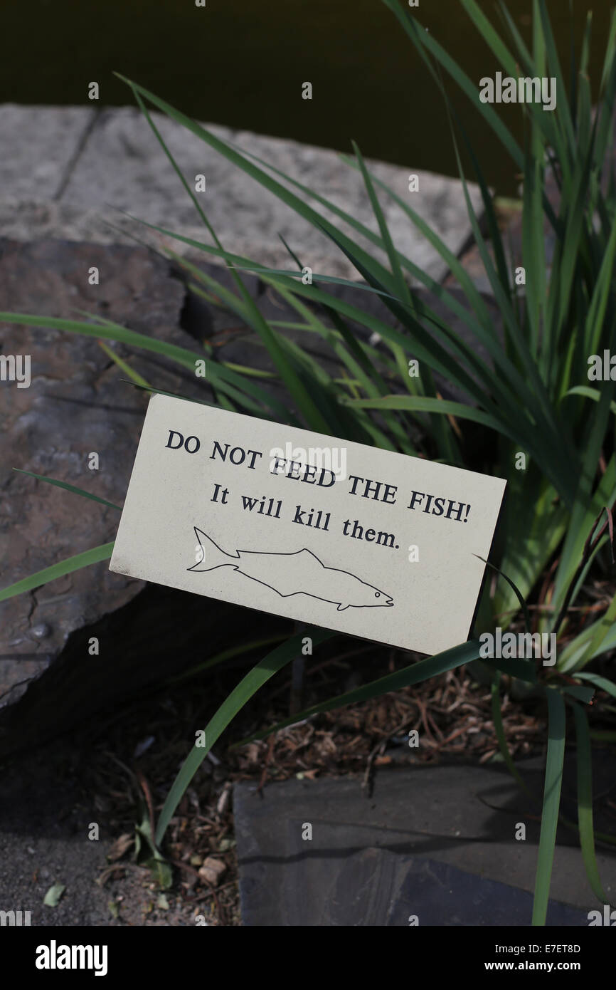 A sign that reads "Do not feed the fish! It will kill them Stock Photo ...