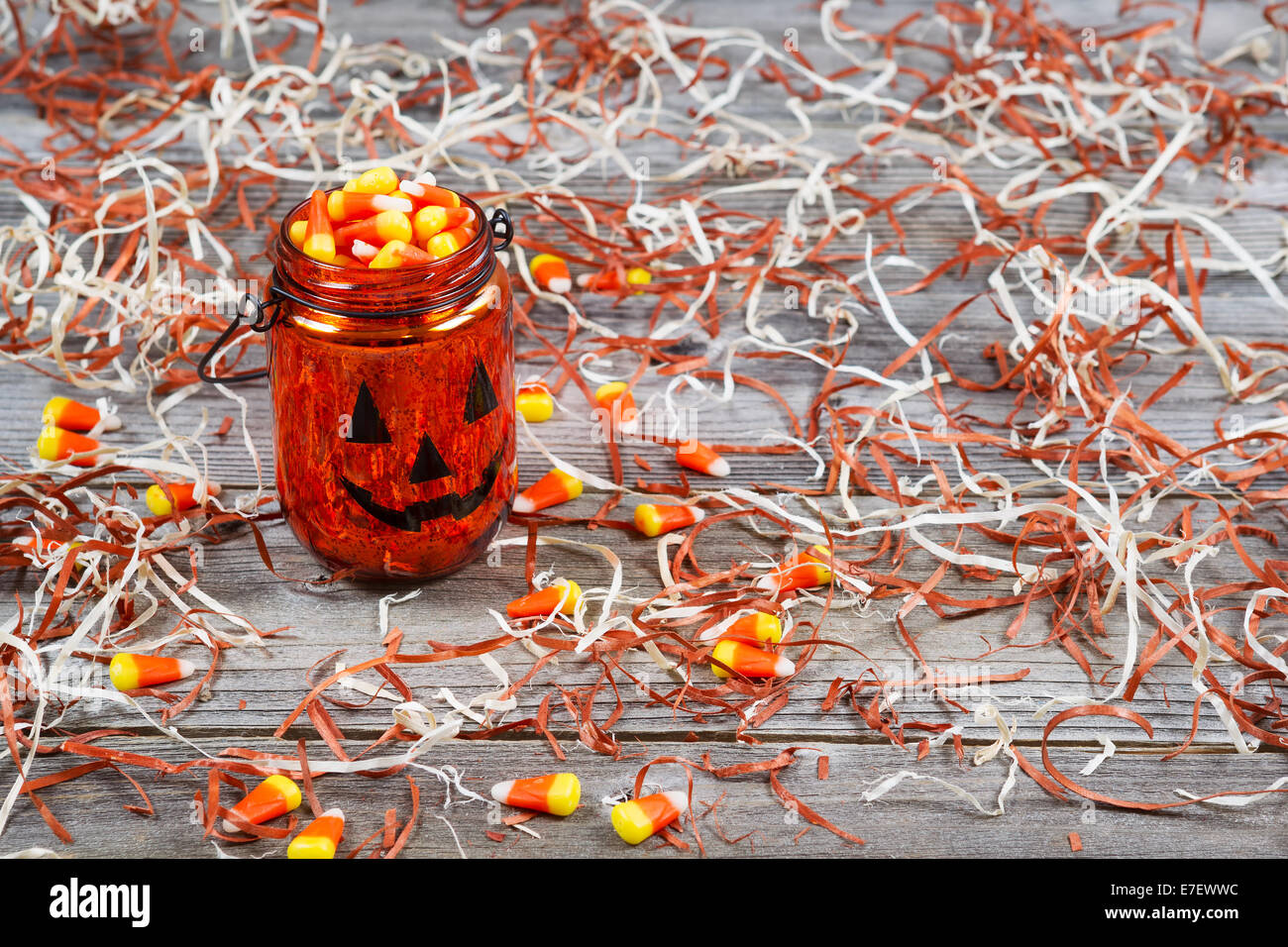 Horizontal image of scary pumpkin jar filled with Halloween candy ...