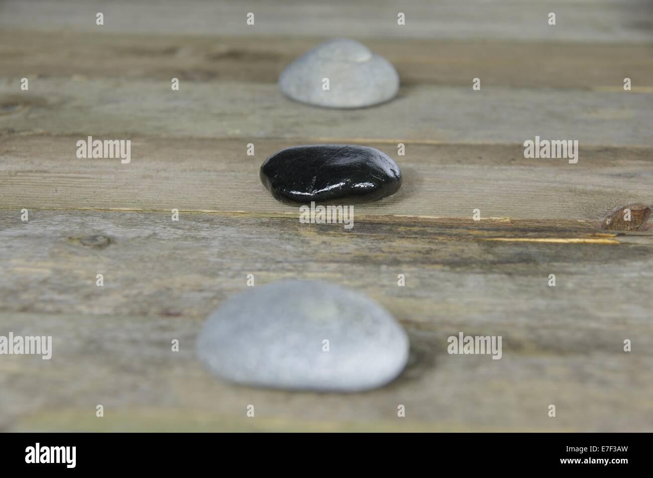 three stones on wooden board Stock Photo - Alamy