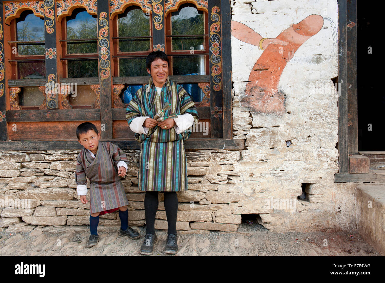 Father and son standing in front of house wall with the mural of a ...