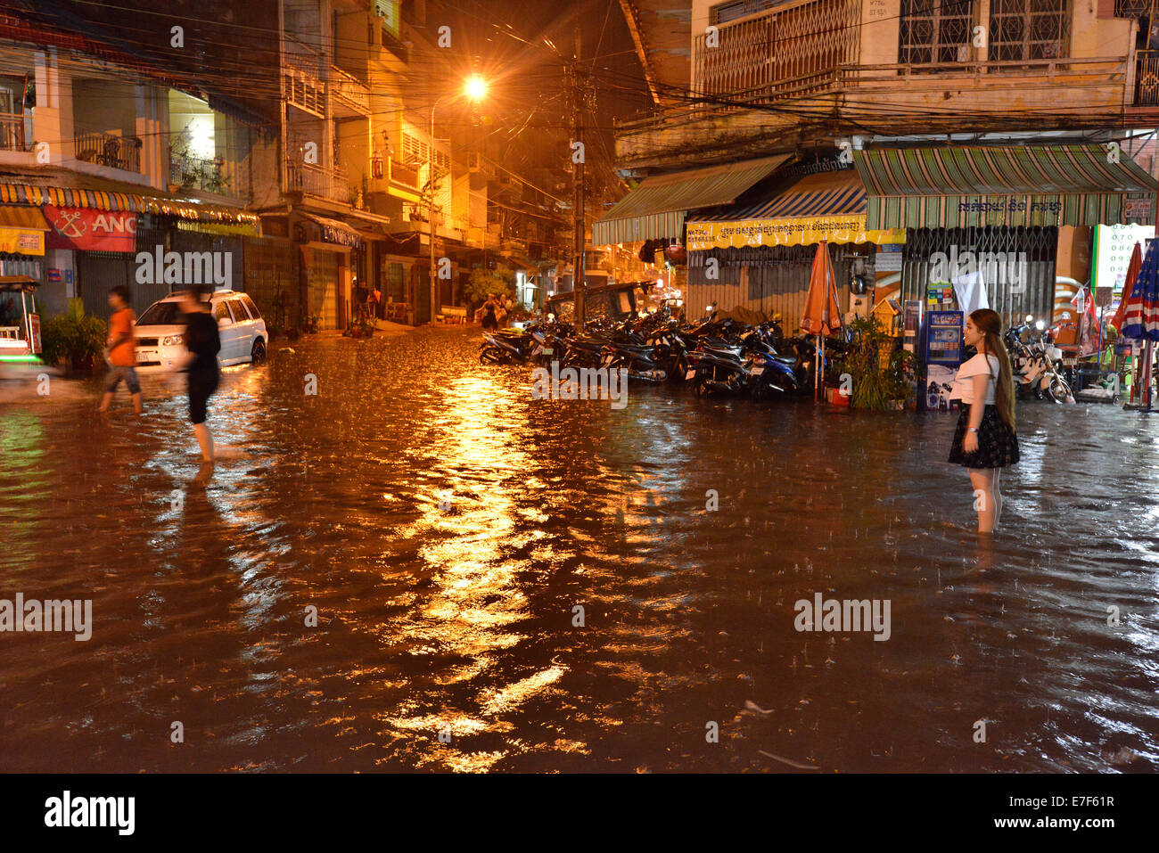 Street scene with a flooded road during heavy monsoon rain at night ...