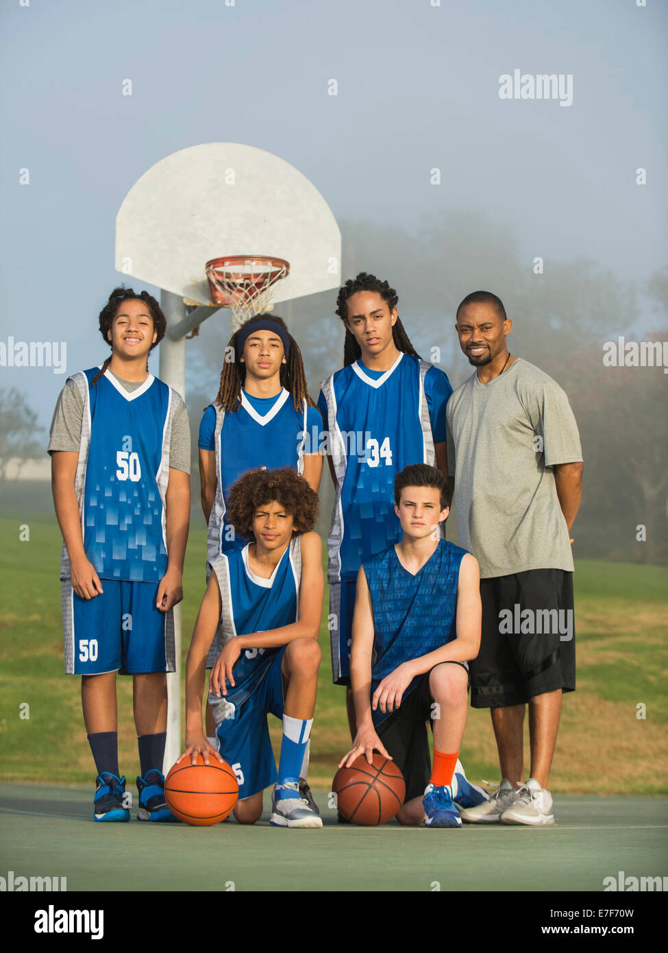 Basketball team posing on court Stock Photo - Alamy