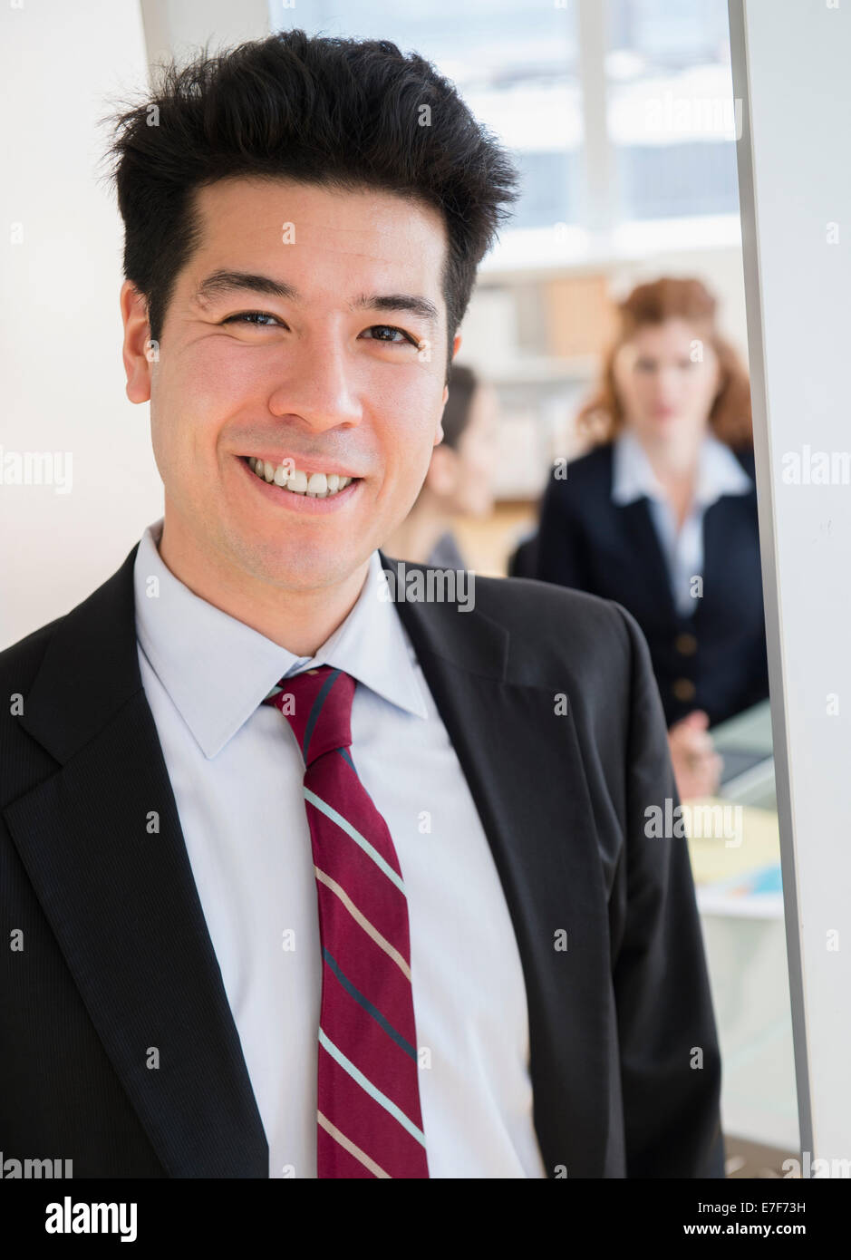 Mixed race businessman smiling in office Stock Photo - Alamy