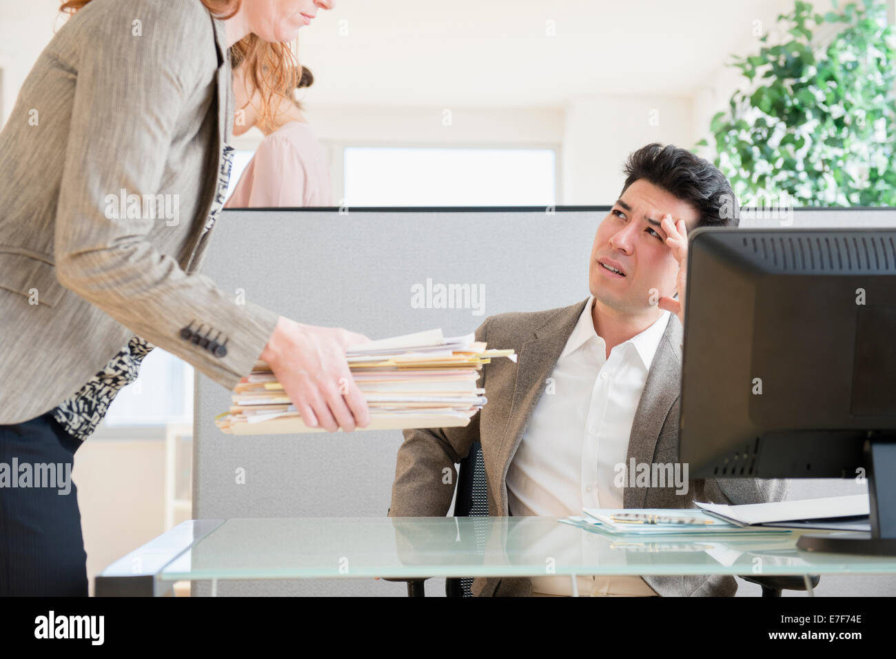 Businesswoman giving colleague stack of papers Stock Photo - Alamy