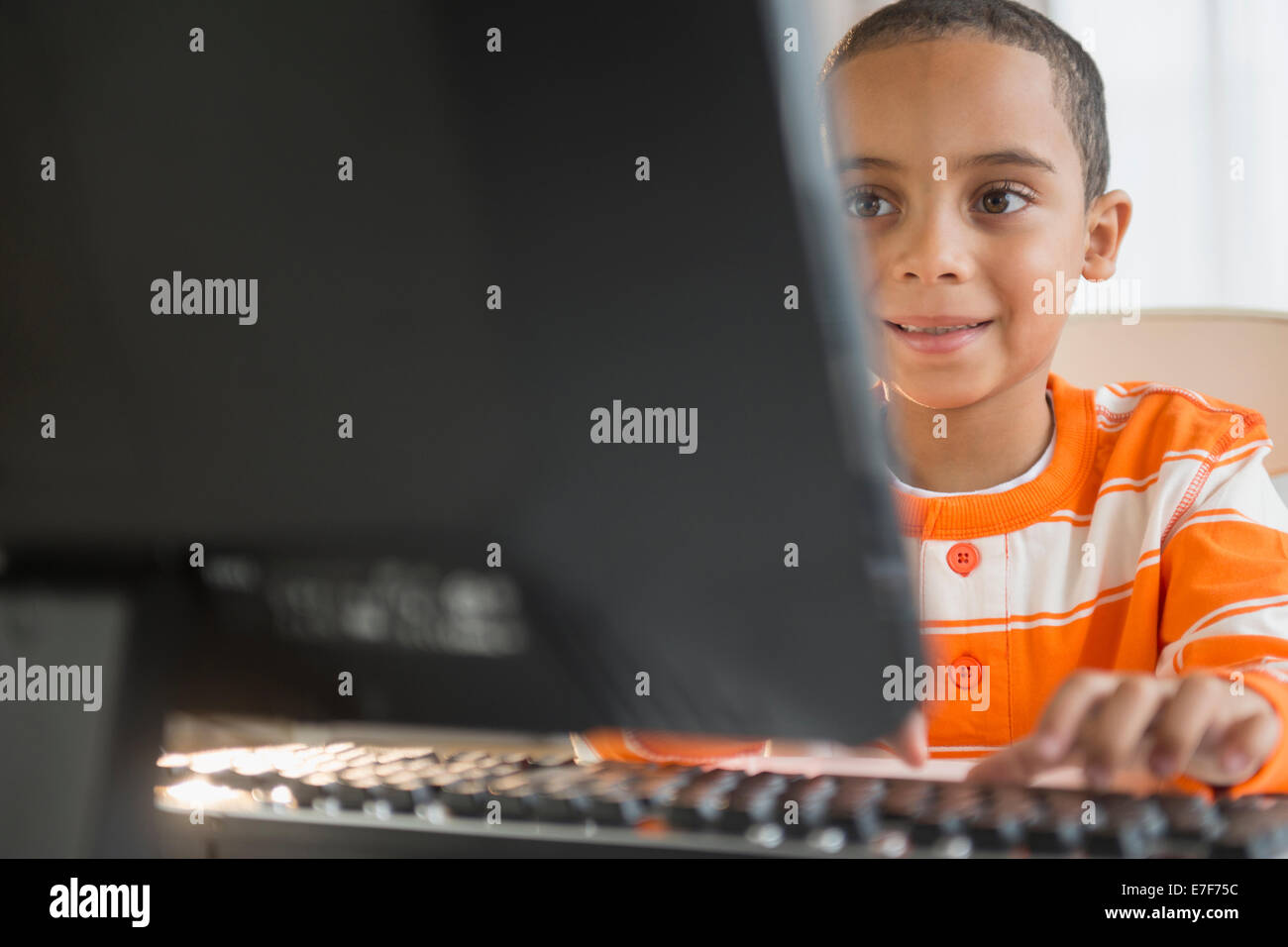Mixed race boy using computer Stock Photo - Alamy