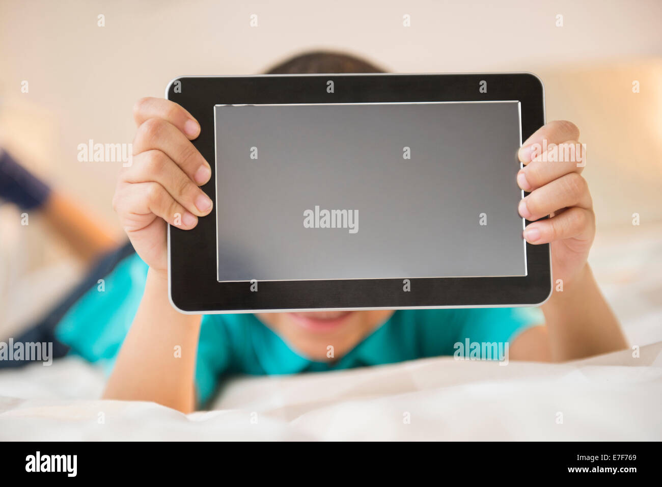 Mixed race boy holding tablet computer Stock Photo - Alamy