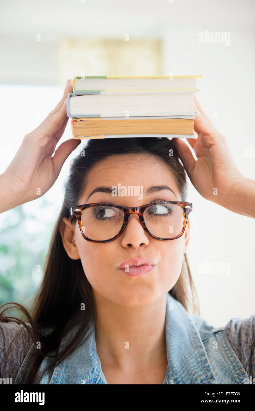 Woman balancing stack of books on her head Stock Photo - Alamy