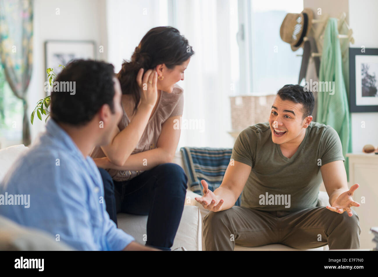 Hispanic friends talking in living room Stock Photo - Alamy