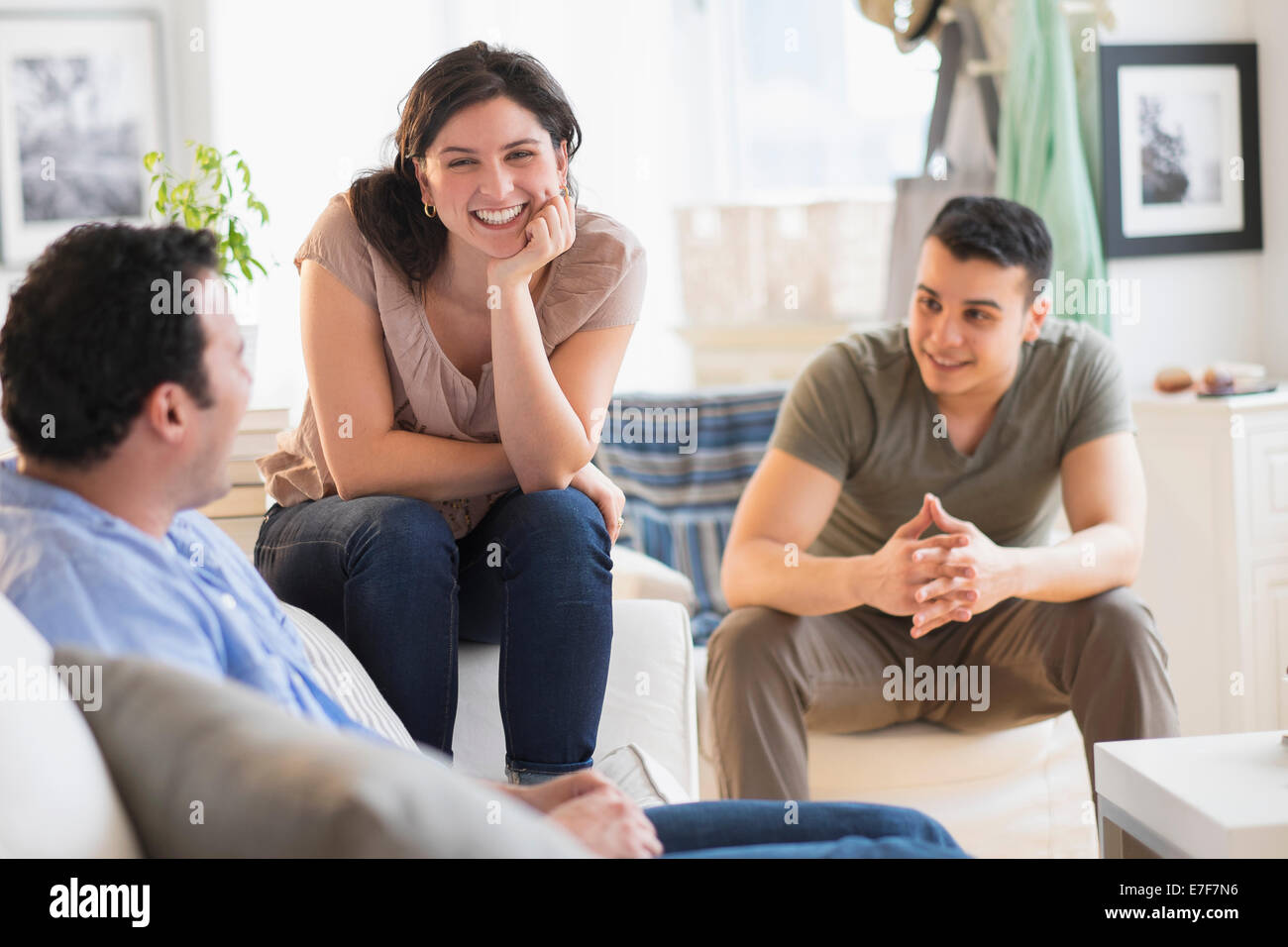 Hispanic friends talking in living room Stock Photo - Alamy