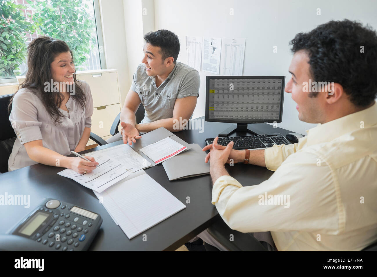 Hispanic businessman talking to clients in office Stock Photo - Alamy