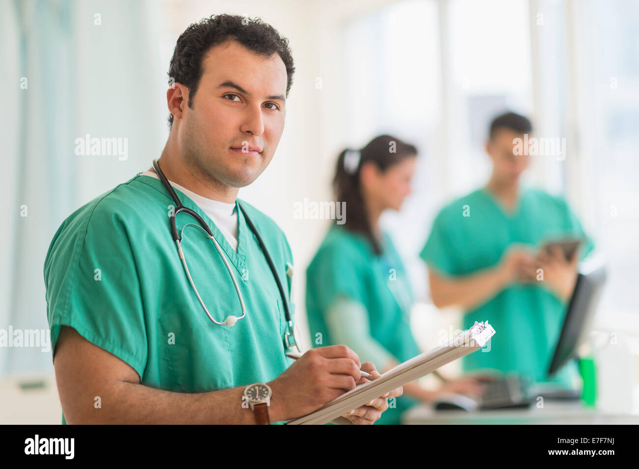 Hispanic nurse reading medical chart in hospital Stock Photo - Alamy