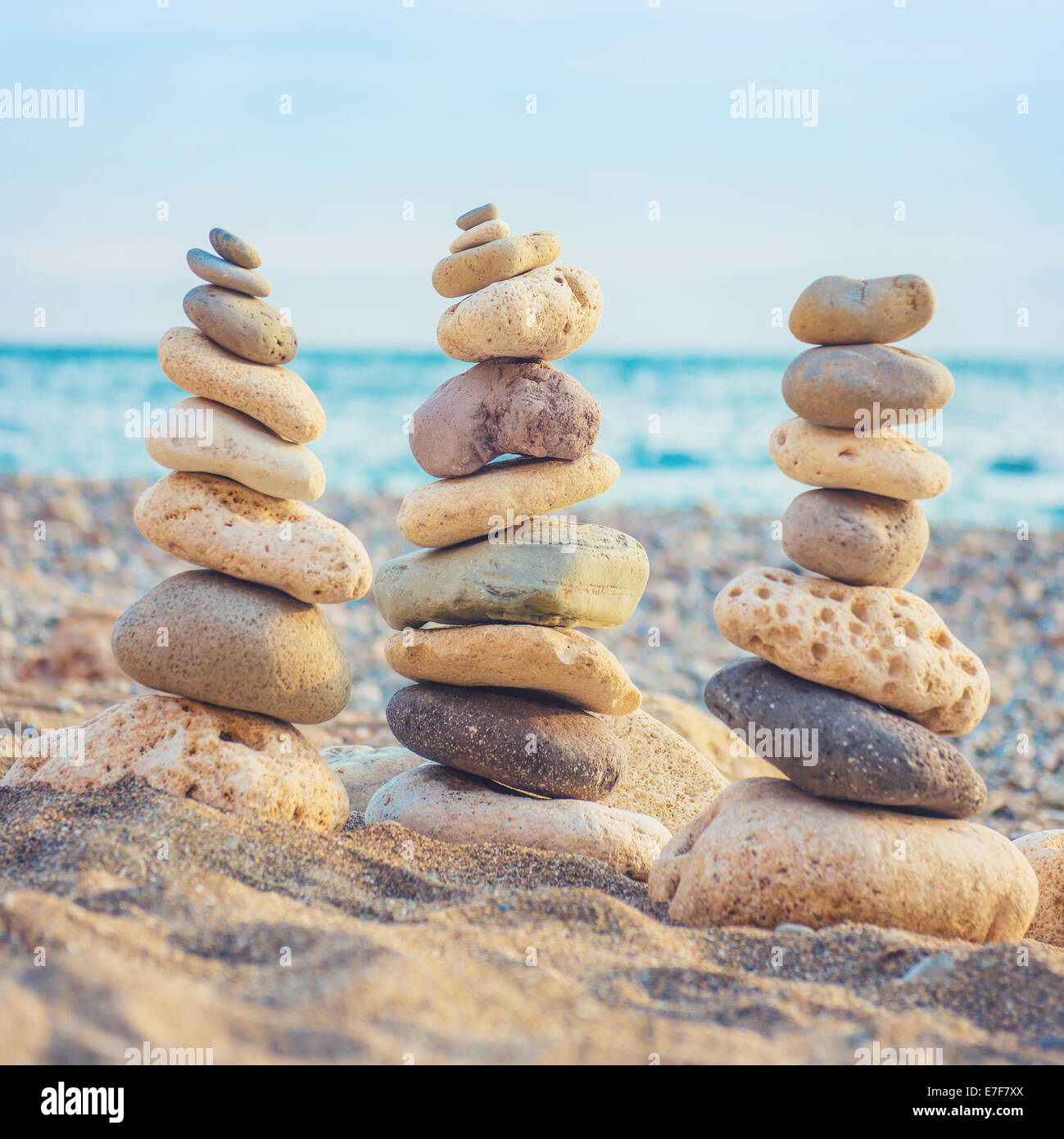 Three stacks of round smooth stones on the beach Stock Photo - Alamy