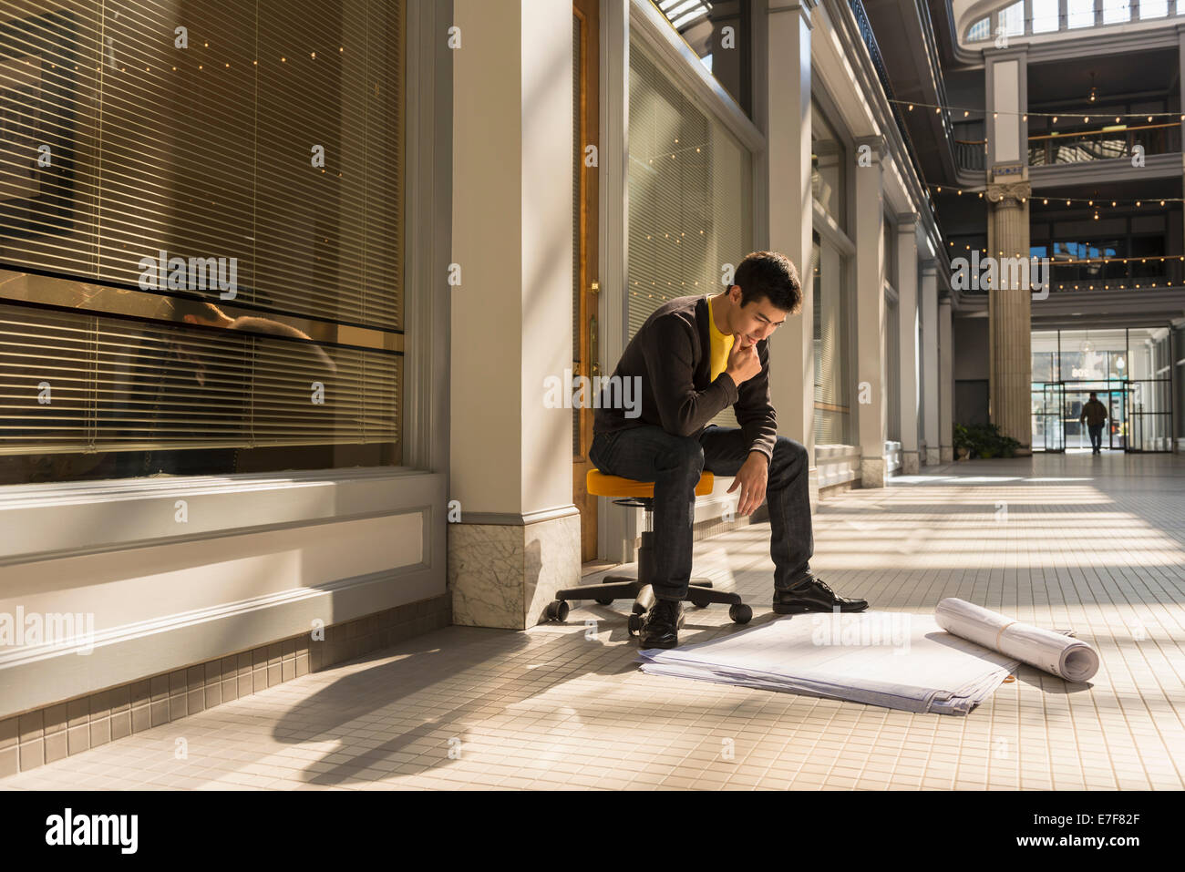 Mixed race man reading blueprints in building Stock Photo - Alamy