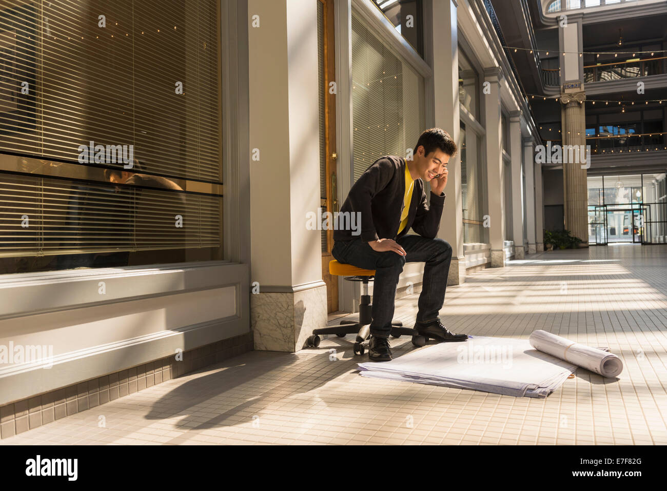 Mixed race man reading blueprints in building Stock Photo - Alamy