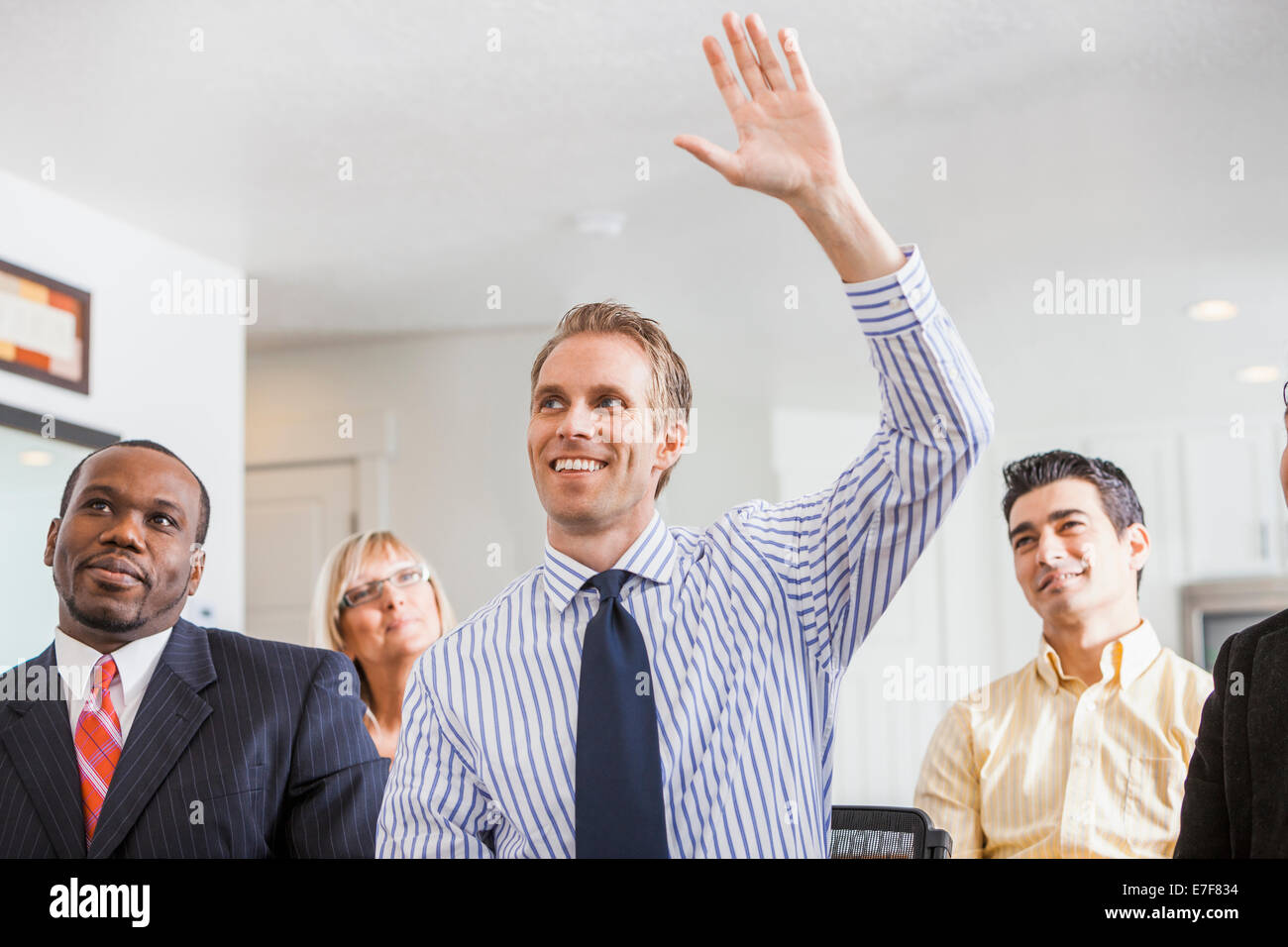 Businessman raising his hand in office Stock Photo - Alamy