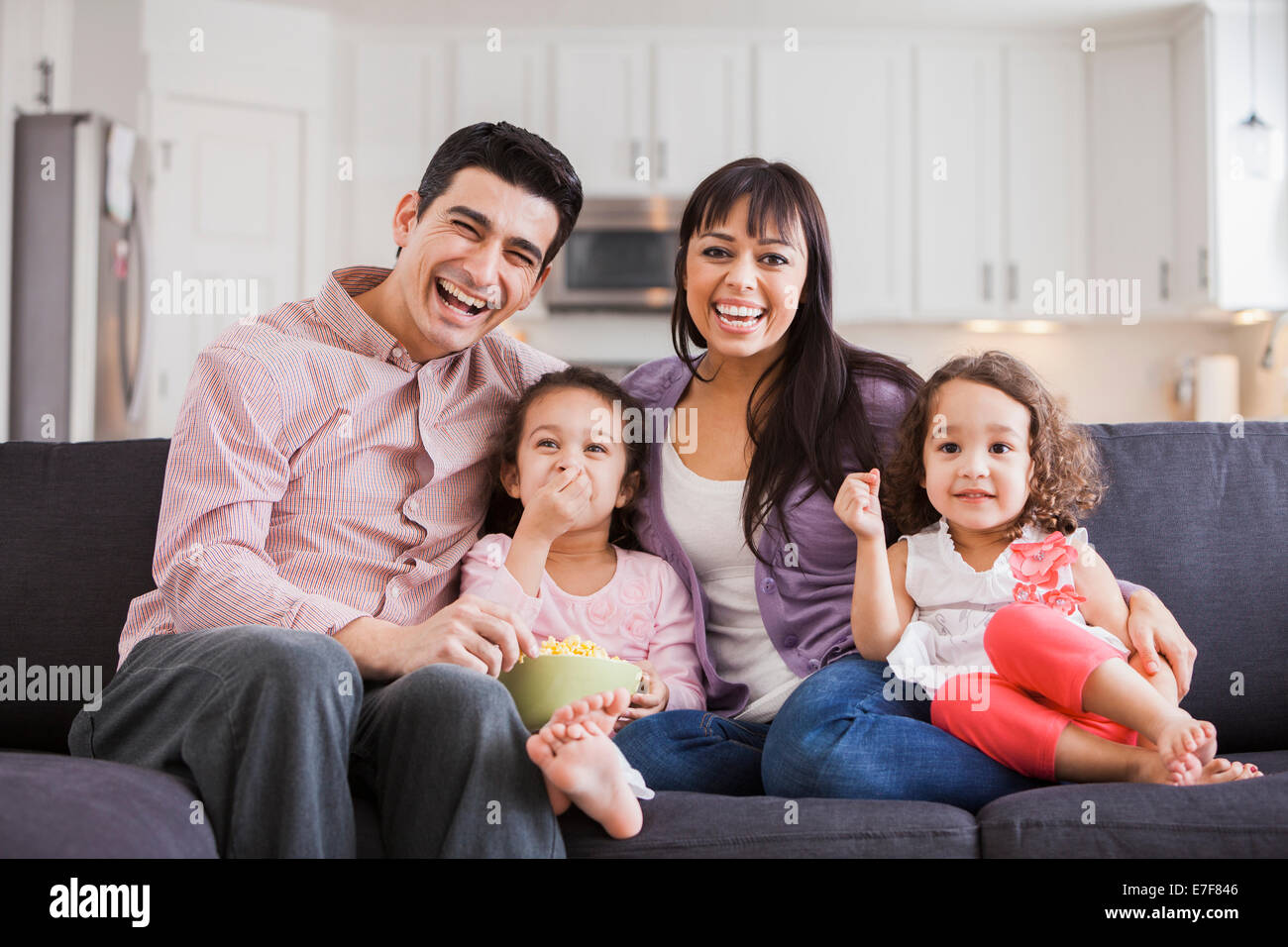 Family smiling together on sofa Stock Photo - Alamy
