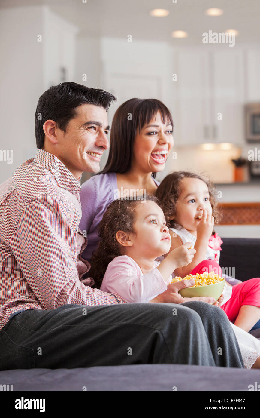 Family watching television together on sofa Stock Photo - Alamy