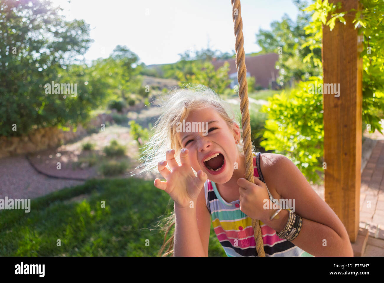 Caucasian girl playing on rope swing Stock Photo - Alamy