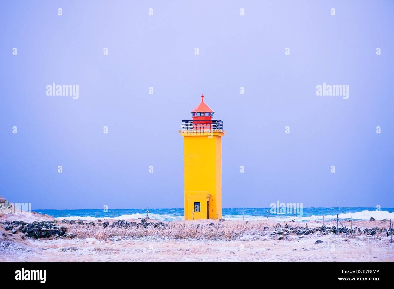 Yellow lighthouse on snowy coastline Stock Photo - Alamy