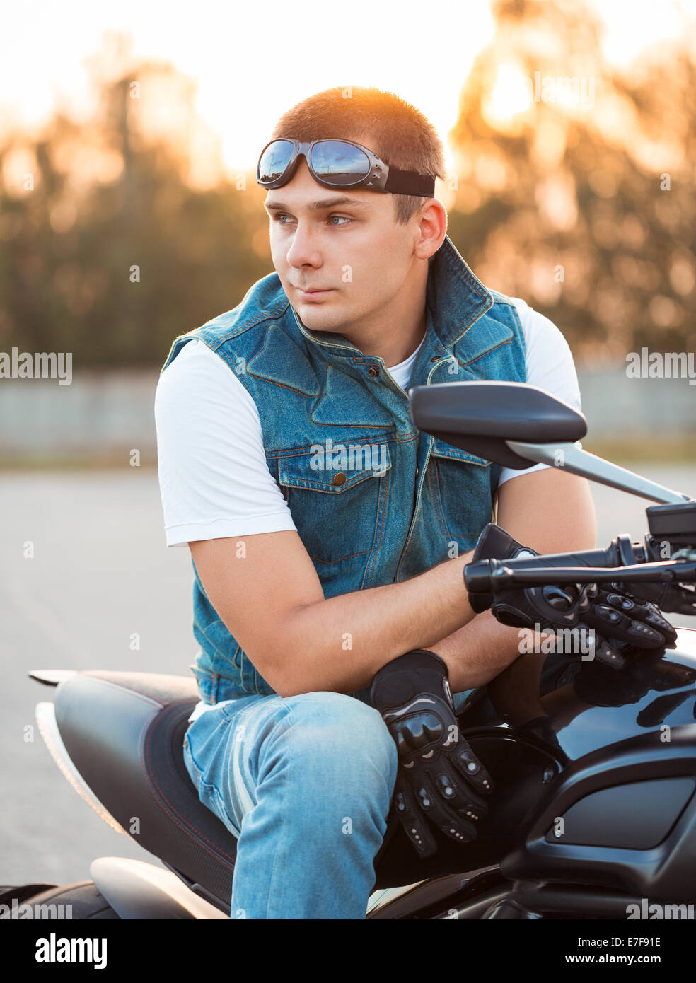 Biker man sitting on his motorcycle outdoors Stock Photo - Alamy