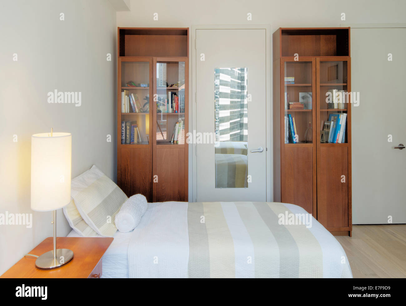 Bed, bookshelves and bedside table in bedroom Stock Photo - Alamy
