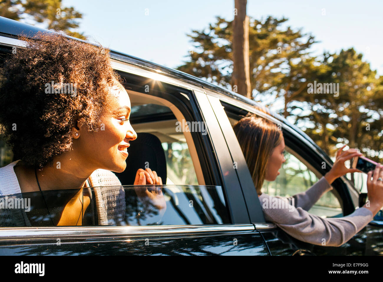 Women taking cell phone picture together in car Stock Photo - Alamy